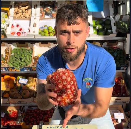 Un frutero muestra (y prueba) una fruta por la que se está llegando a ...